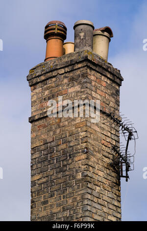 Victorian domestic chimney with four assorted chimney-pots against a ...