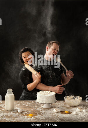 Messy couple baking cake Stock Photo - Alamy