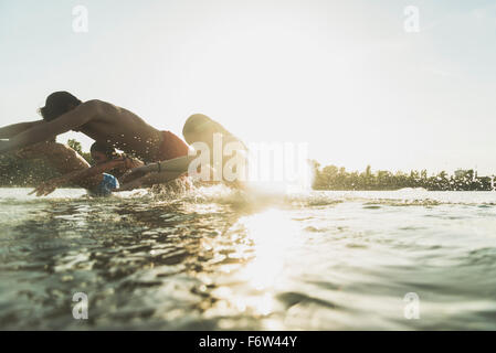 Happy friends splashing in water Stock Photo - Alamy