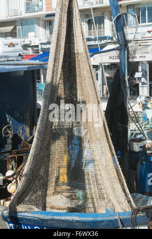 Fishing nets hanging on a boat that is docked in the harbor Stock Photo ...