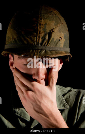 Soldier suffering with P.T.S.D./shell shock with his hand over his face ...