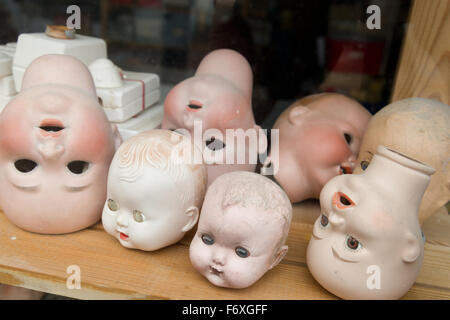 Dolls heads through the window of a doll repair shop Stock Photo - Alamy