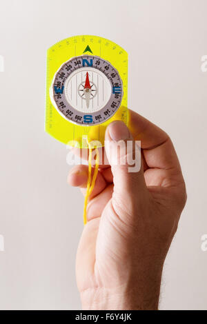 man's hand holding out a compass showing him the way shot in the studio ...