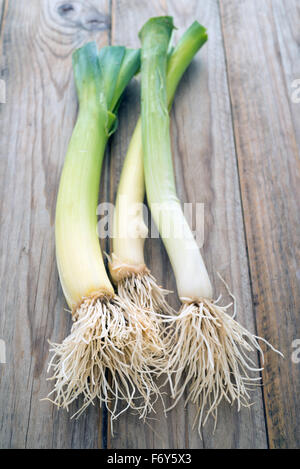 leeks on wooden table Stock Photo - Alamy