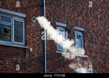 Steam coming out of a central heating flue on a house wall, England, UK ...