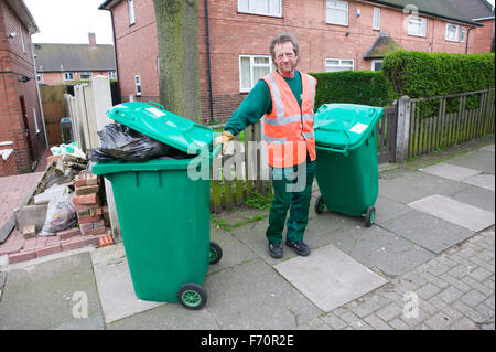 Bin man collecting wheelie bins on a housing estate in England Stock ...