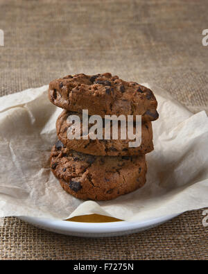 Chocolate chip cookies on burlap and on old wooden table, top view ...