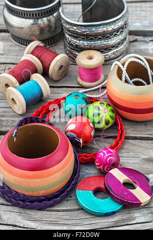 Stylish beads and spools of thread on wooden background Stock Photo - Alamy