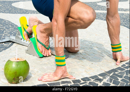 Brazilian athlete wearing flip flops crouching at the start position in ...