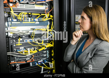thoughtful woman looking at server while working in data center Stock ...