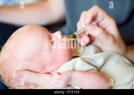 Giving infant medication Stock Photo - Alamy
