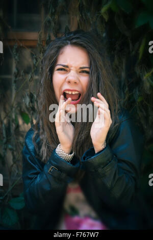 Furious beautiful brunette girl screaming with hands up isolated over ...