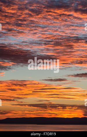 Beautiful red and orange sunset over the sea in a cloudy sky. The sun ...