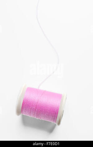 Spool of pink sewing thread isolated on white Stock Photo - Alamy