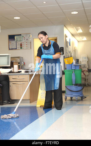 A hospital cleaner mops the floor in the ward administration area in a ...