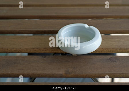 empty white ashtray on a wooden table Stock Photo - Alamy