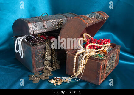 Two wooden treasure chests with valuables on blue textile Stock Photo ...
