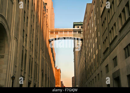 A walkway connecting two office buildings high above the street. Sunset ...