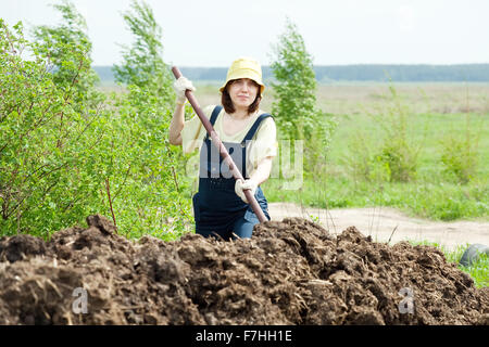 Woman works with animal manure at field Stock Photo - Alamy