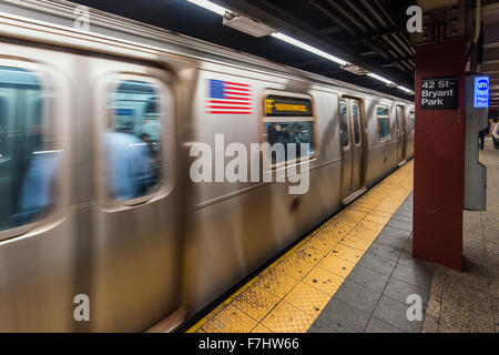 A New York City subway train waits at a station platform, framed by a ...