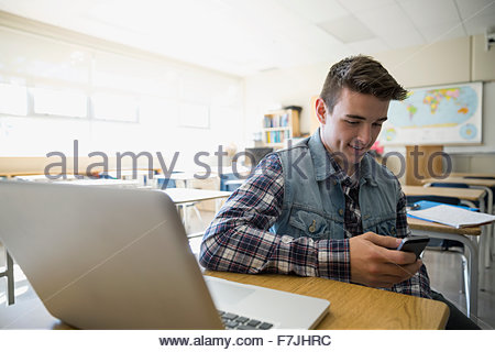 Education, phone and student texting in a classroom, social media and ...