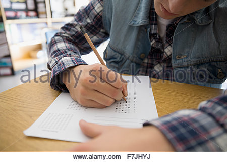 A close up view of a student completing an examination paper using a ...