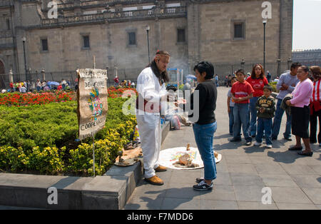 Mexican shaman performing a cleansing ceremony on a woman in the Zocalo ...