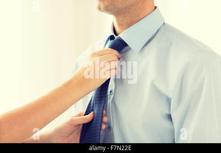 Woman adjusting mans tie Stock Photo - Alamy