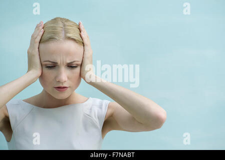 Woman holding hands over ears with eyes closed Stock Photo - Alamy