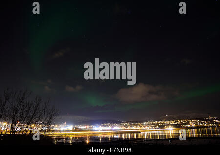 magnificent aurora borealis over arctic city lights, fjord and mountain ...