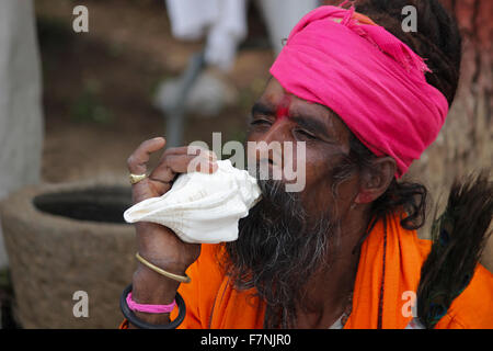 An Indian sadhu (holy man) blowing a conch shell, a symbol for god ...
