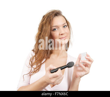 Girl putting facial powder on her face with a brush, white background ...