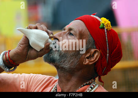 An Indian sadhu (holy man) blowing a conch shell, a symbol for god ...