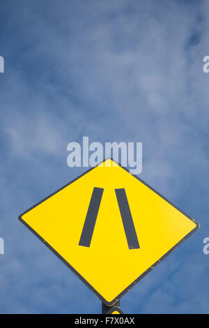 Road Narrowing Sign against Blue Sky Background Stock Photo - Alamy