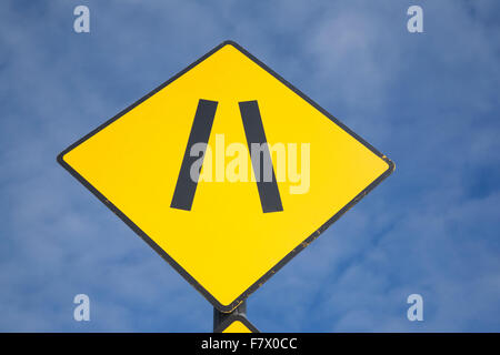 Road Narrowing Sign against Blue Sky Background Stock Photo - Alamy