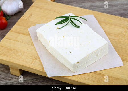 White bulgarian cheese brinza with rosemary on the wood background ...