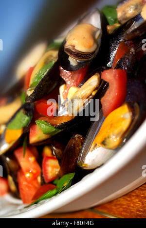 Close up on clams, muscles, shrimp rice and peas cooking in a giant ...