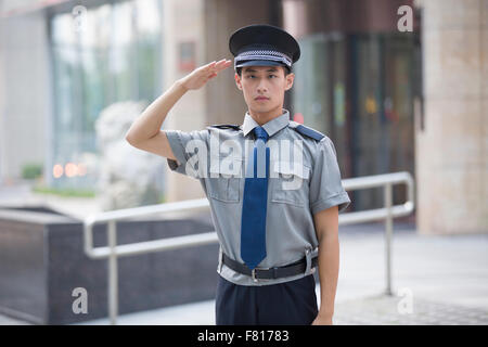Portrait of security guard saluting while working at gate Stock Photo ...
