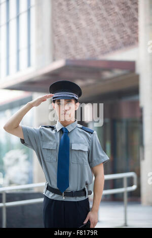 Portrait of security guard saluting while working at gate Stock Photo ...