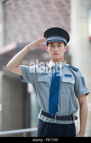 Portrait of security guard saluting while working at gate Stock Photo ...