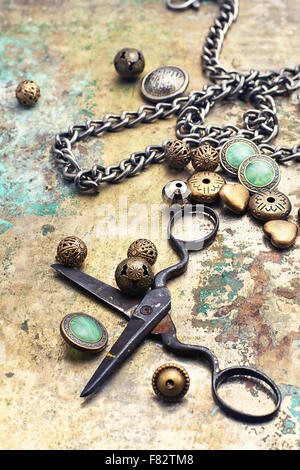 Metal beads,buttons,chain and scissors on retro background Stock Photo ...
