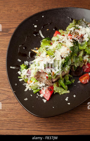 Fillet of beef with vegetable salad on wooden table Stock Photo - Alamy