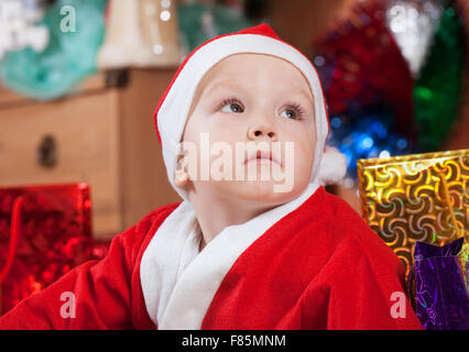 Boy dressed like Santa Claus with Christmas gifts at home Stock Photo ...