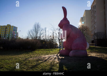 giant pink rabbit eating a headless human body statue Stock Photo - Alamy