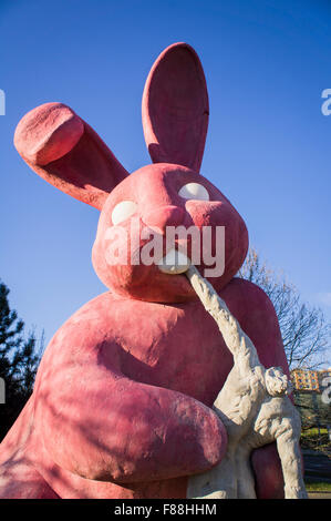 giant pink rabbit eating a headless human body statue Stock Photo - Alamy