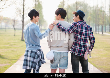 Three men putting their arms around each other's shoulders and toasting ...