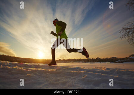 Young sportsman running in snow in rural environment Stock Photo - Alamy