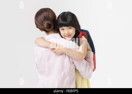 Daughter hugging her mother both staring forward with a smile Stock Photo - Alamy