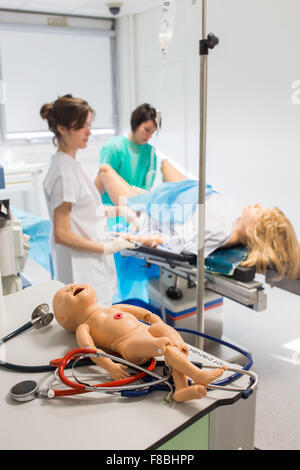 Student midwife delivering a baby mannequin from an adult mannequin ...