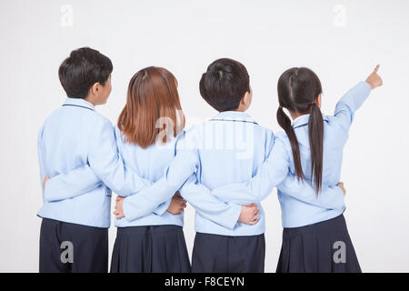 Back appearance of four elementary school students in school uniforms ...